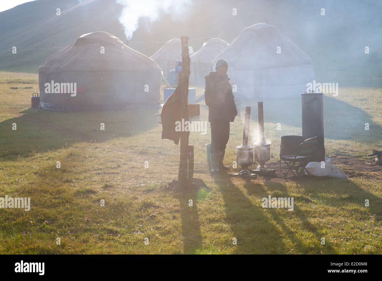 Kyrgyzstan Naryn Province teen boy standing by the samovars at a yurt ...