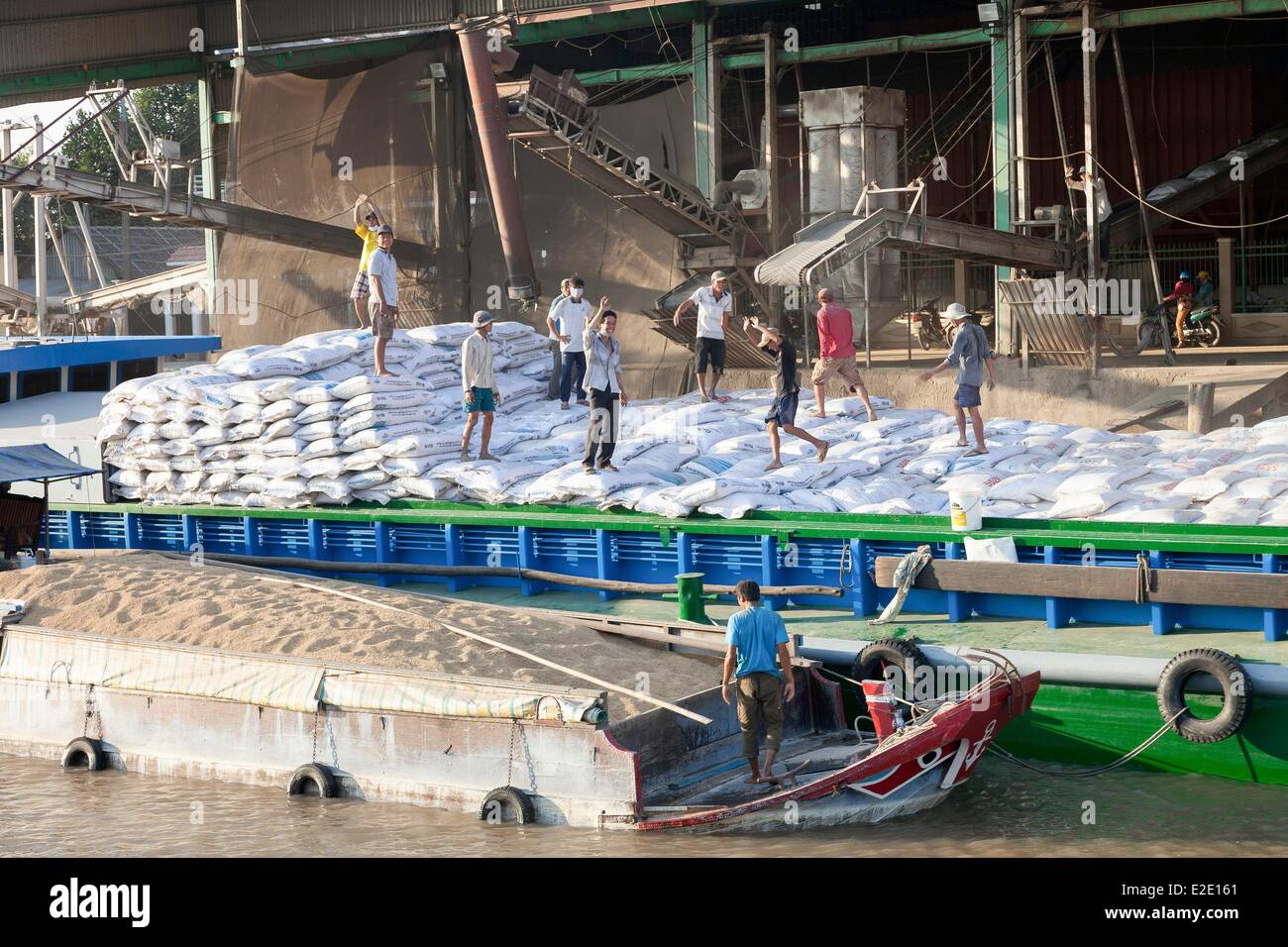 Vietnam Vinh Long Mekong Delta region people loading bags of rice on a ...