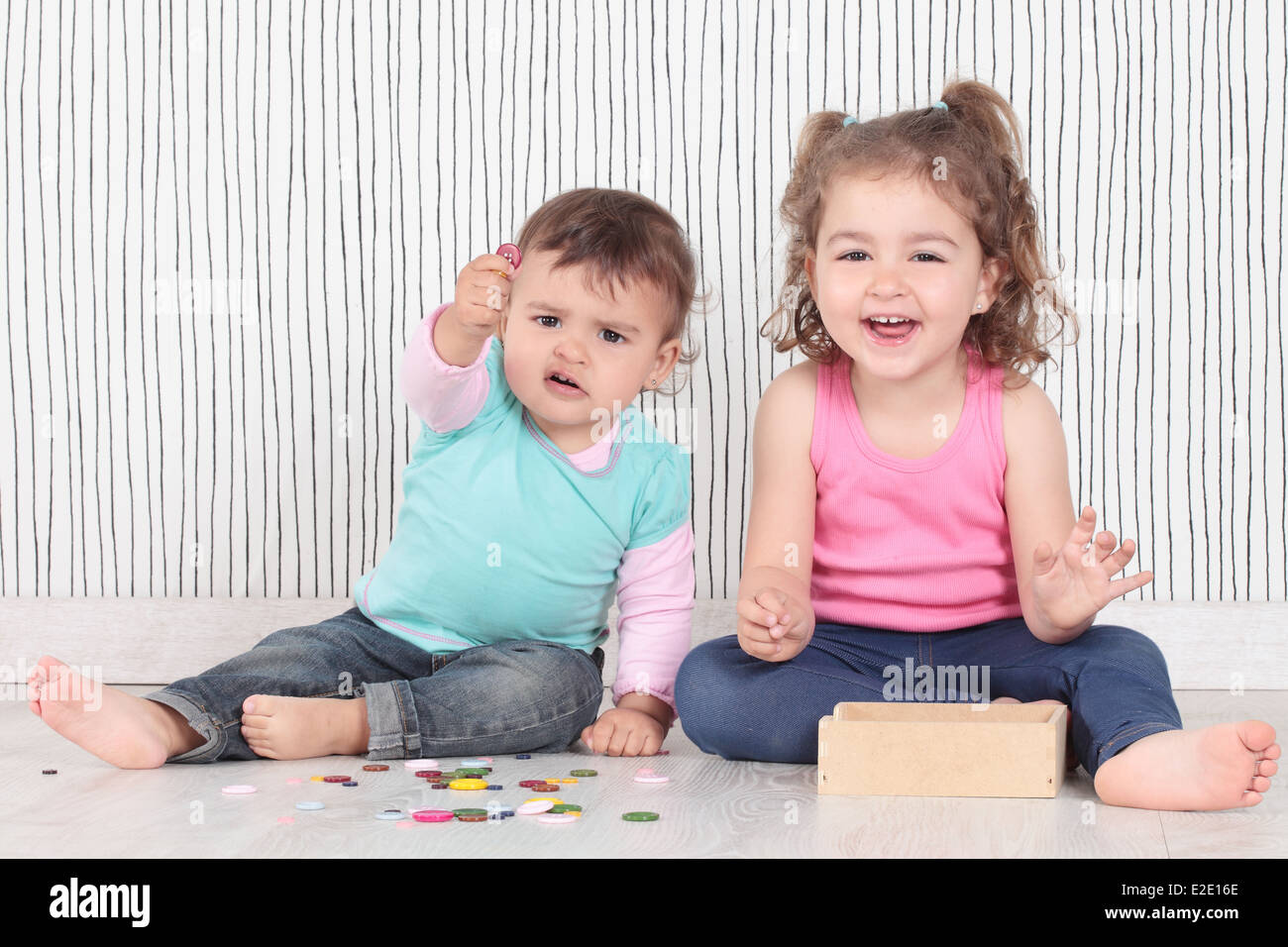 two little sister playing with some buttons Stock Photo - Alamy
