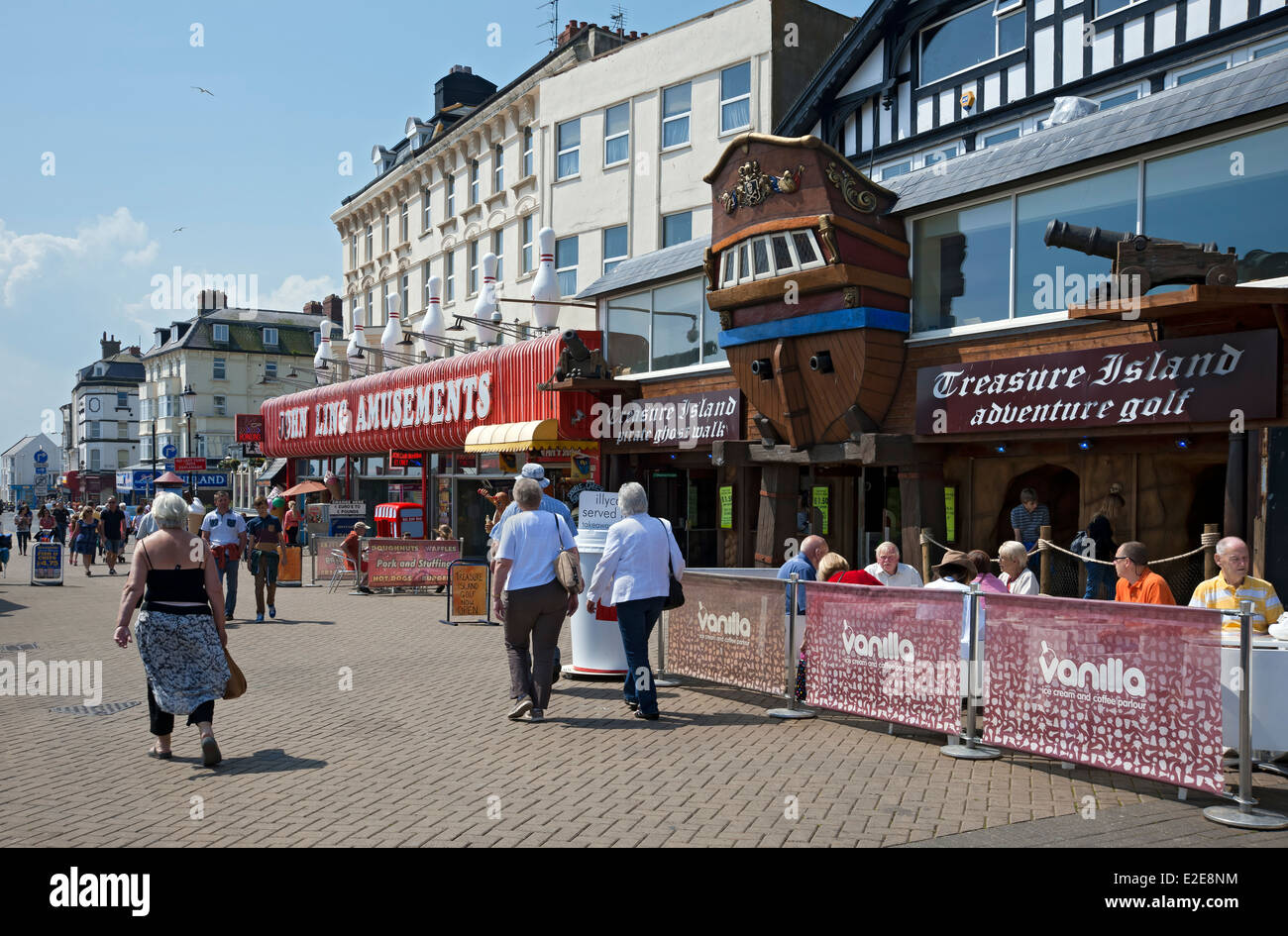 People tourists visitors walking by amusements on the seafront in ...