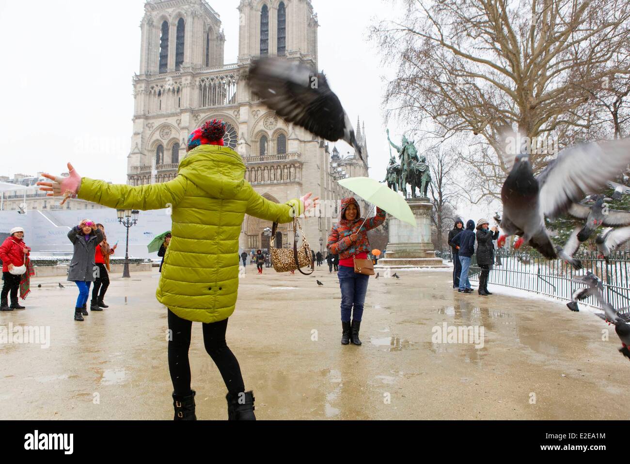 France, Paris, tourists and Notre Dame de Paris cathedral under snow ...