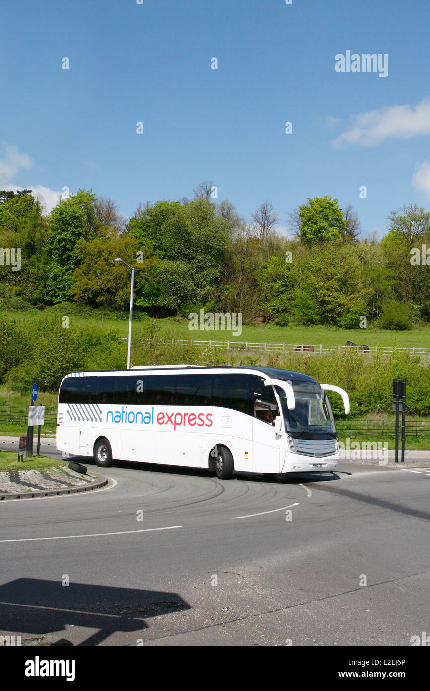 A National Express coach traveling around a roundabout in Coulsdon ...