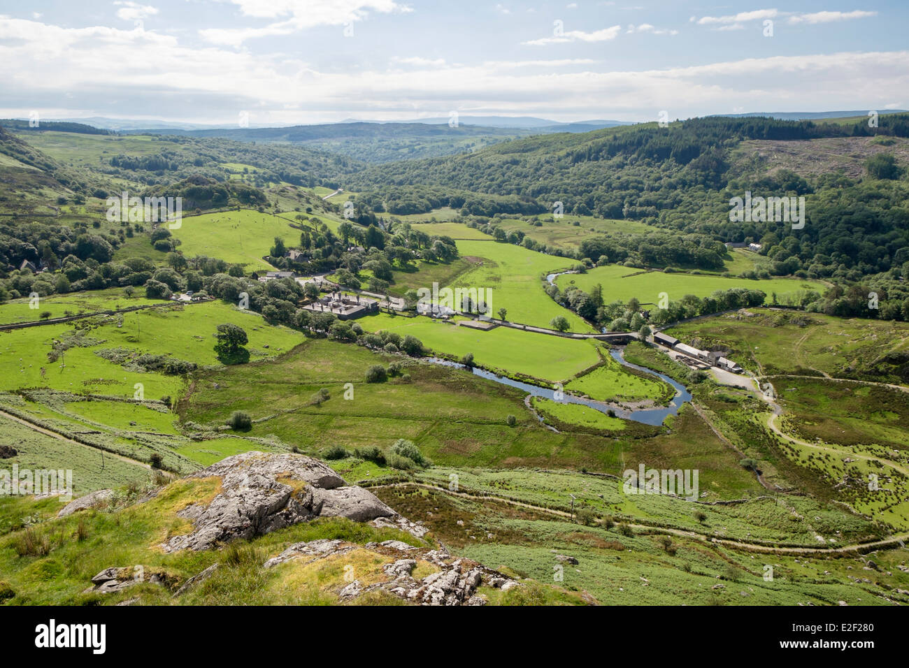 Aerial view above village and Afon Llugwy River in green valley looking ...