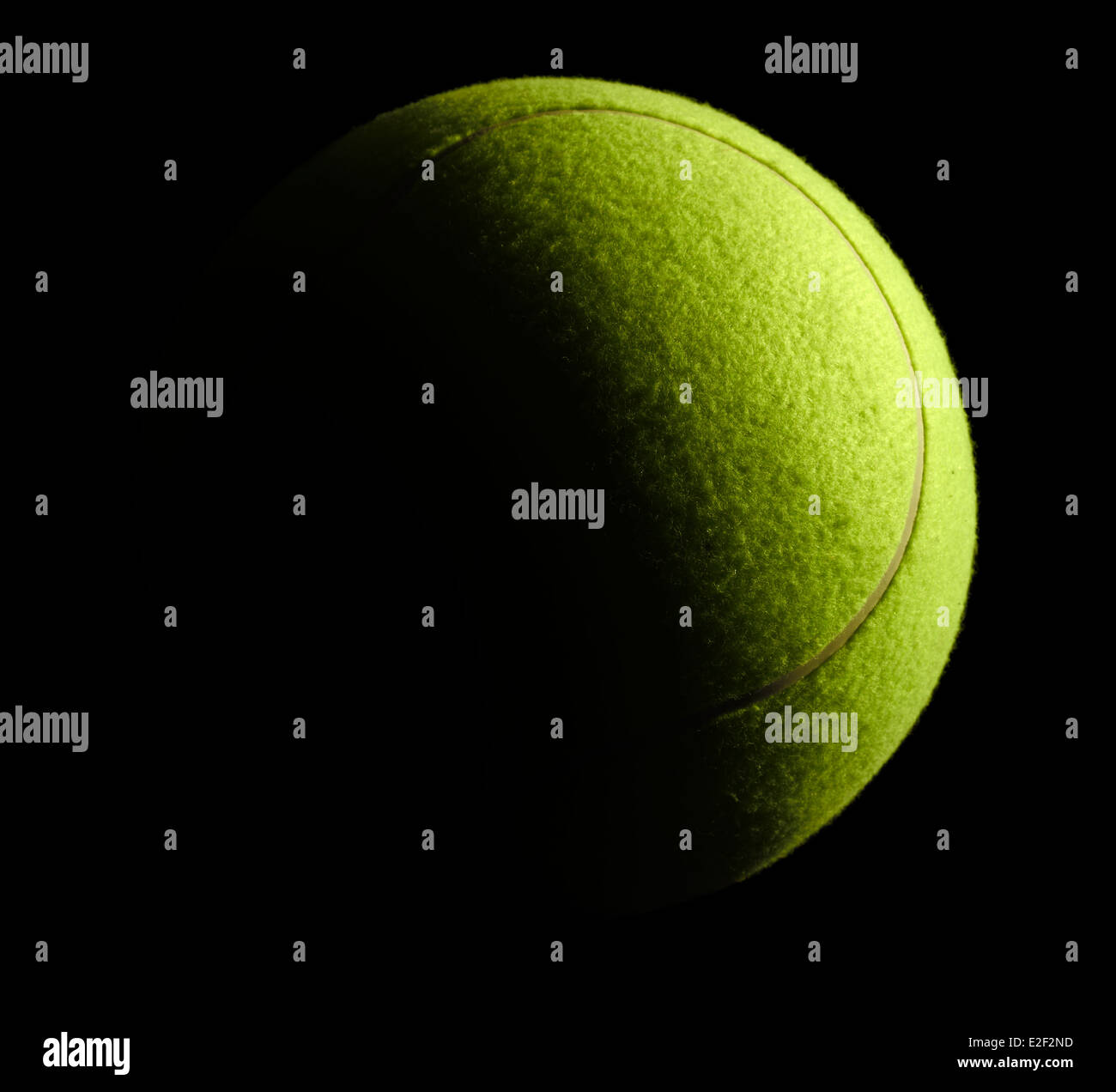 a yellow tennis ball in black back Stock Photo - Alamy