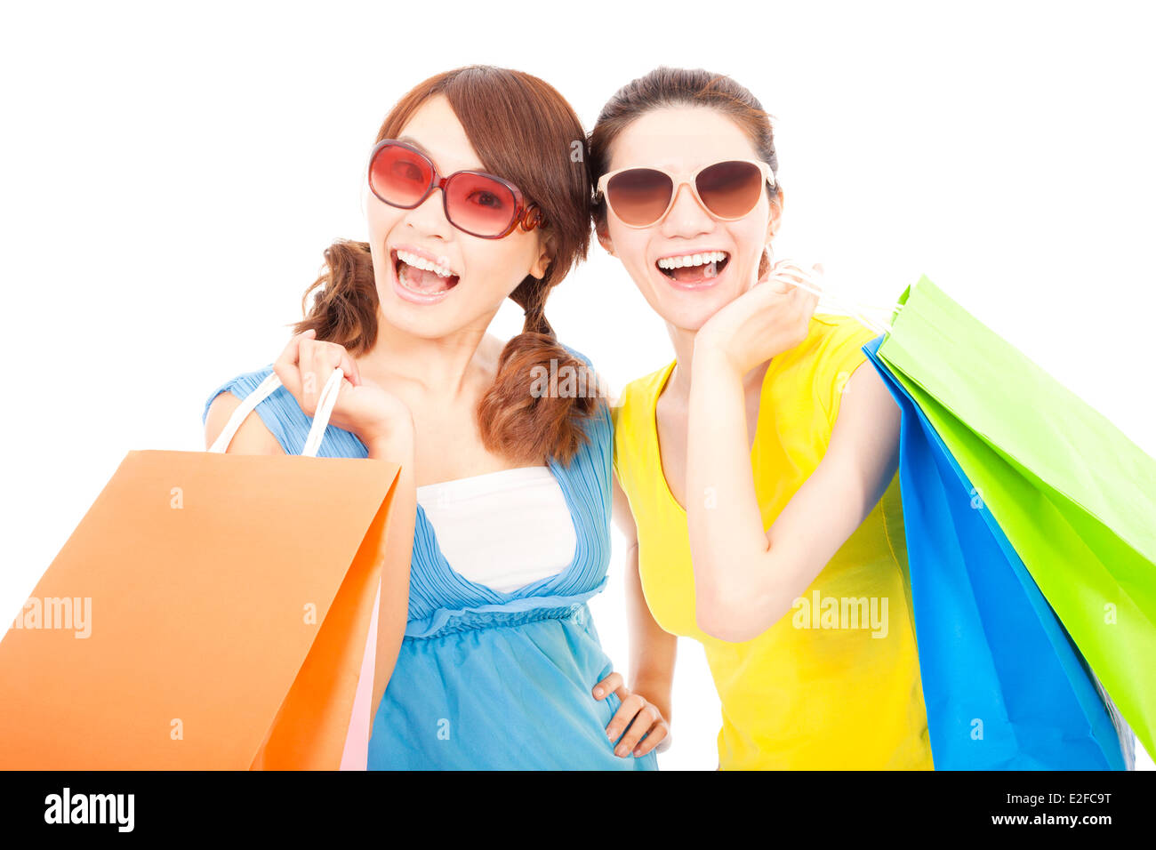 happy young sisters holding shopping bags Stock Photo - Alamy