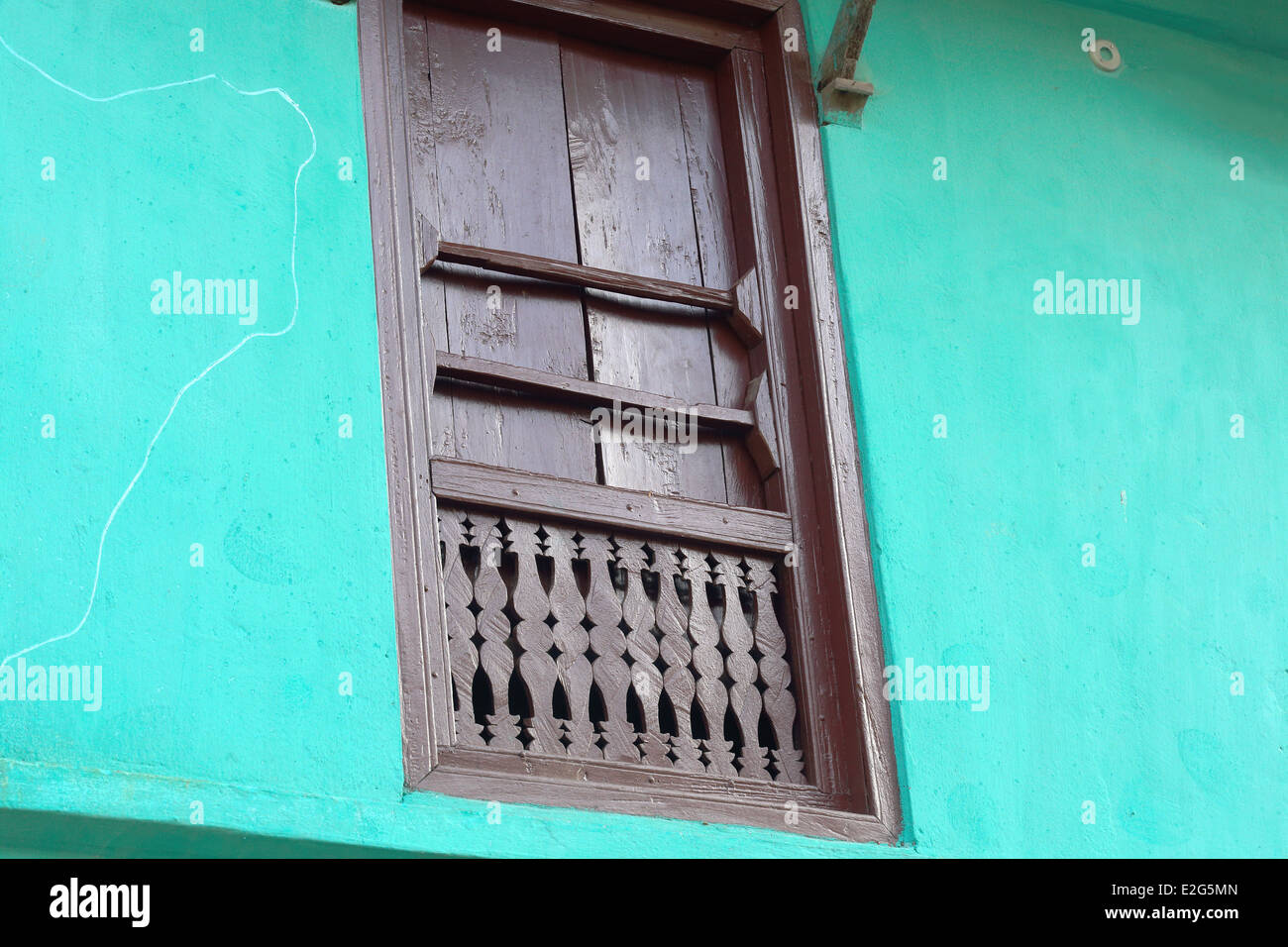 Brown painted wooden window on the green wall of a traditional newari ...