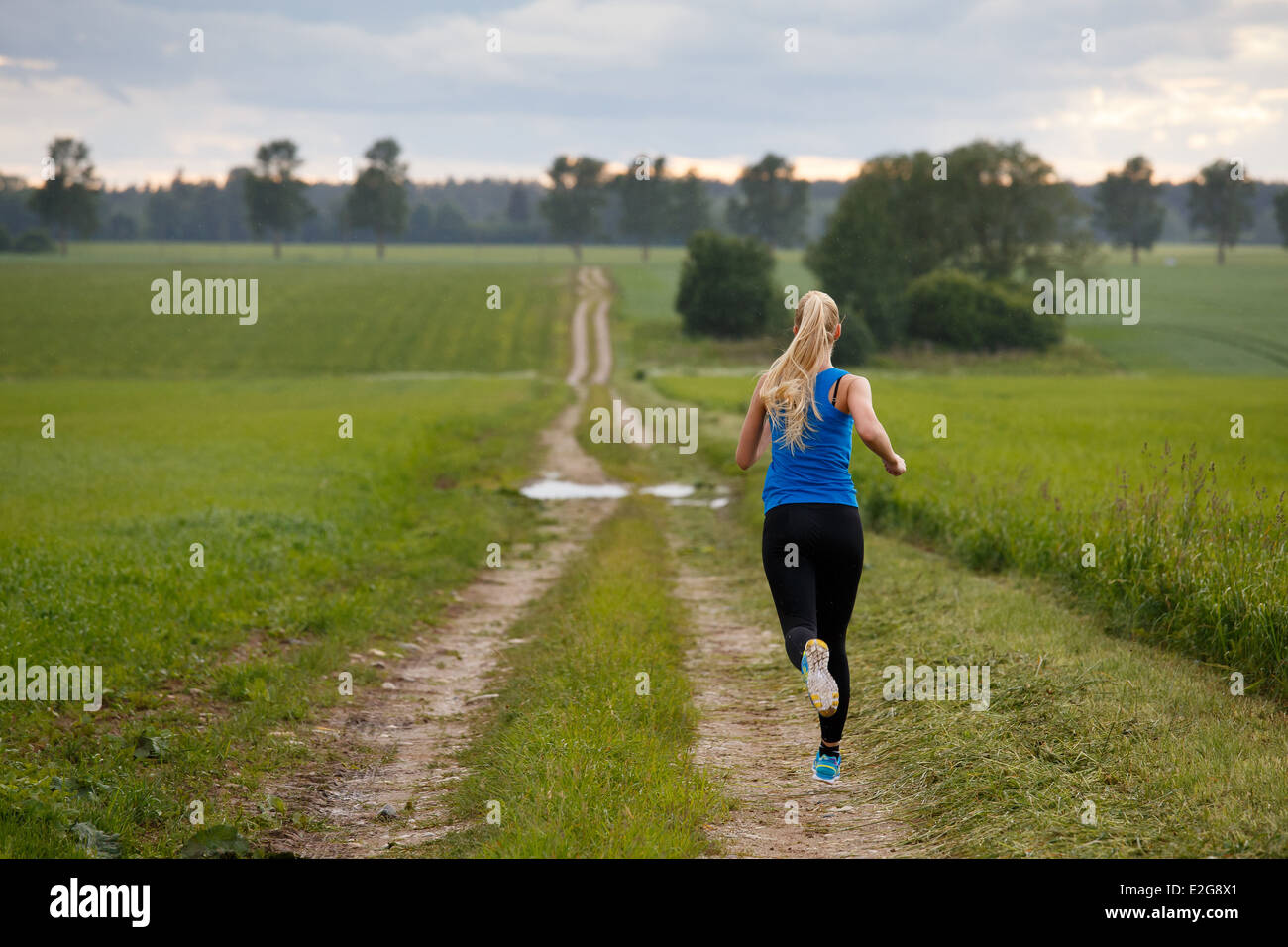 Blonde woman running in nature Stock Photo - Alamy