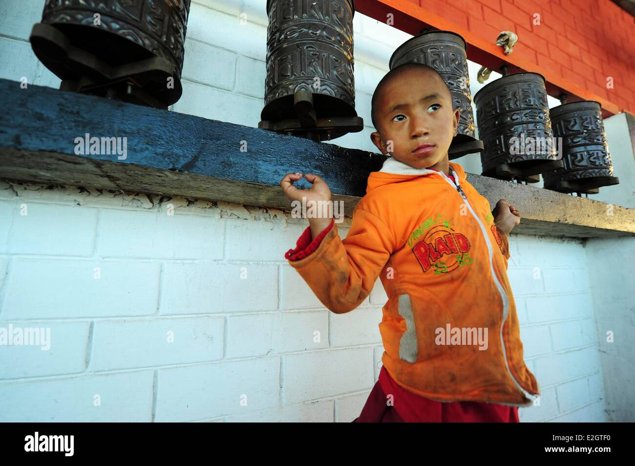 India West Bengal state Meghma monk boy next to prayer wheel Stock ...