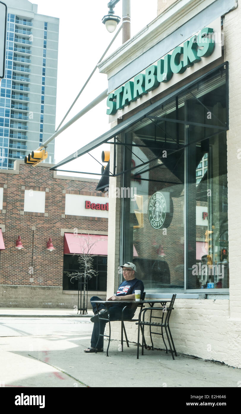 One man sitting with coffee outside coffee shop Stock Photo - Alamy