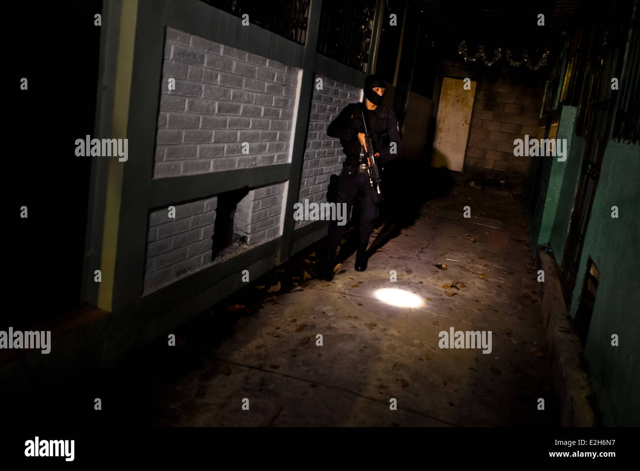 A policeman from the special anti-gang unit patrols during a night raid ...