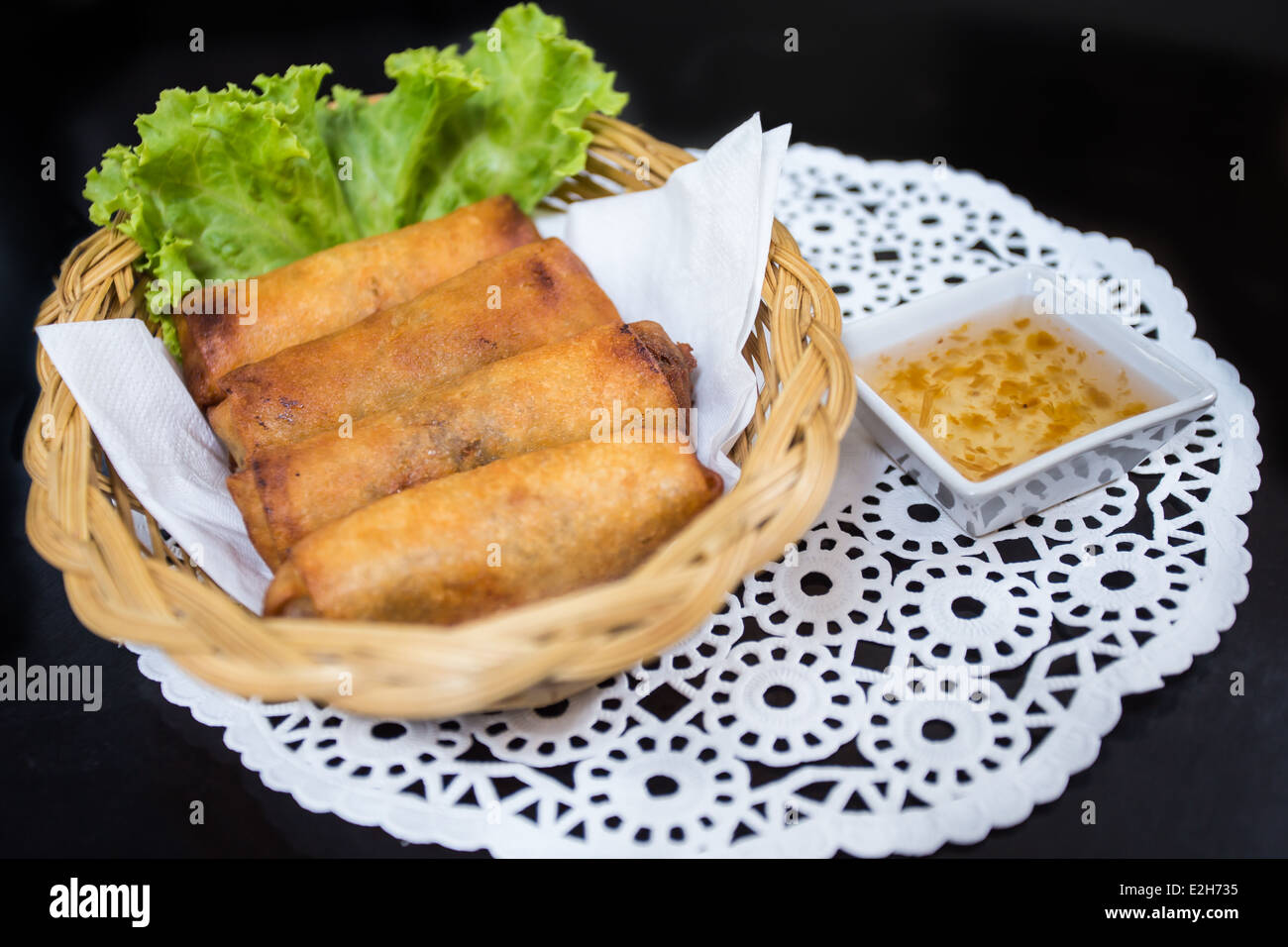 Fried Spring Rolls (Por Pia Tod) with sweet syrup sauce on black table ...