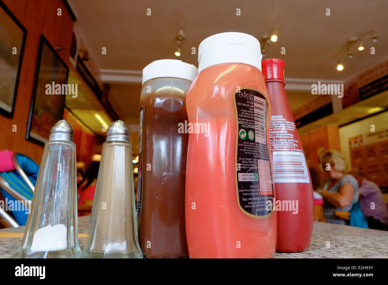 Salt pepper brown and red sauce condiments on a café table England UK ...