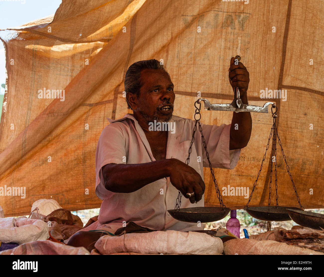 Vendor holding scales, Indian market, Chinnamanur, Tamil Nadu, India ...