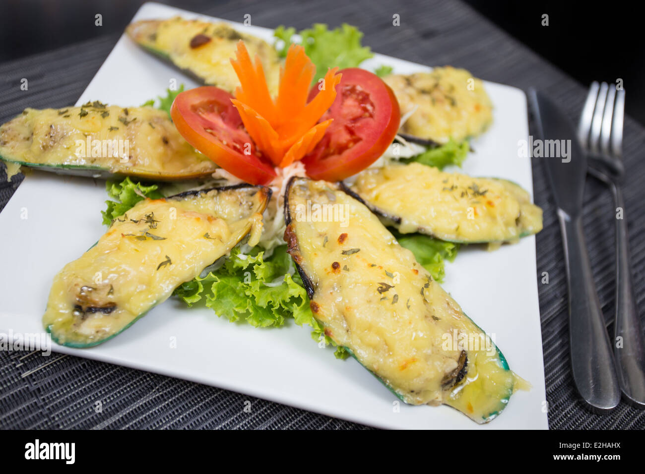 Steamed Mussels baked with cheese on white dish Stock Photo - Alamy