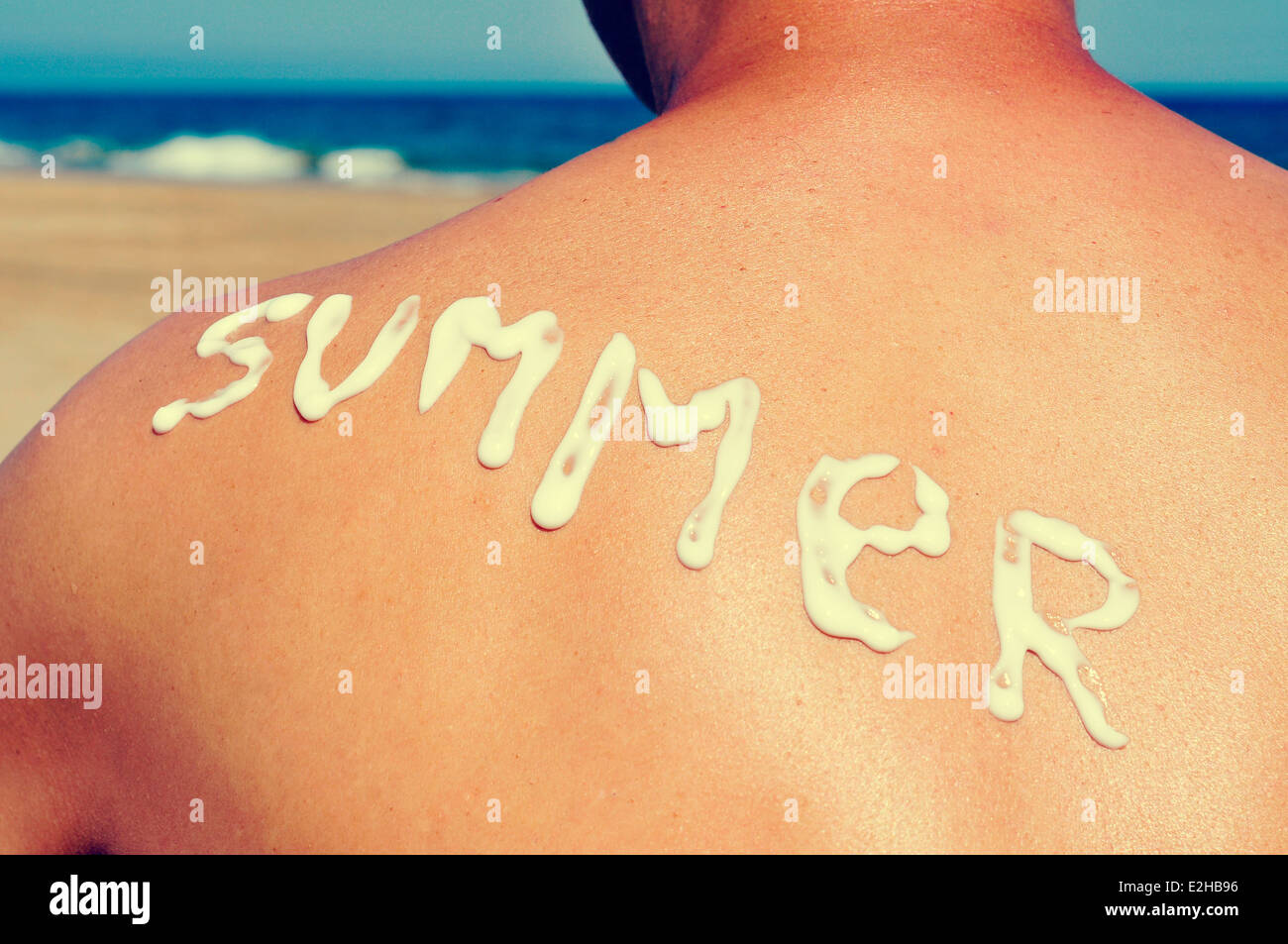 the word summer written with sunblock on the back of a man who is ...
