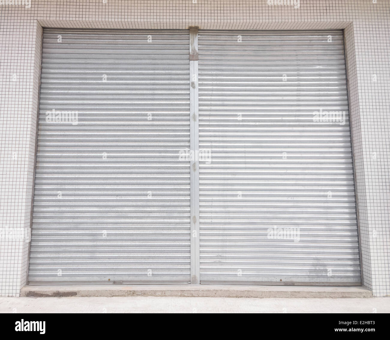 blank metal shutter doors on commercial shop front Stock Photo - Alamy