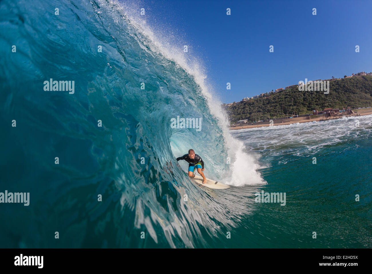Surfer surfing rides inside hollow ocean blue wave crashing tube ride ...
