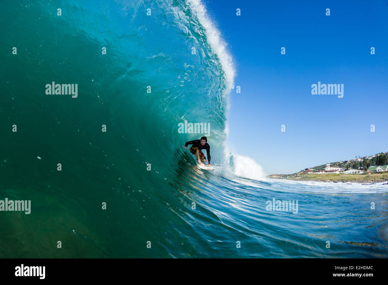 Surfer surfing inside hollow ocean wave closeup swimming water action ...
