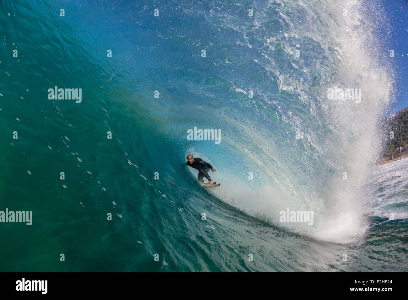 Surfer surfing rides Inside large hollow tubing crashing wave a ...
