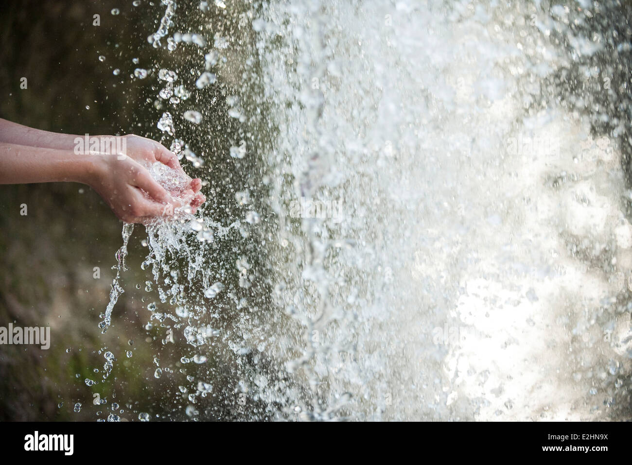 Child holding hands under waterfall, cropped Stock Photo - Alamy