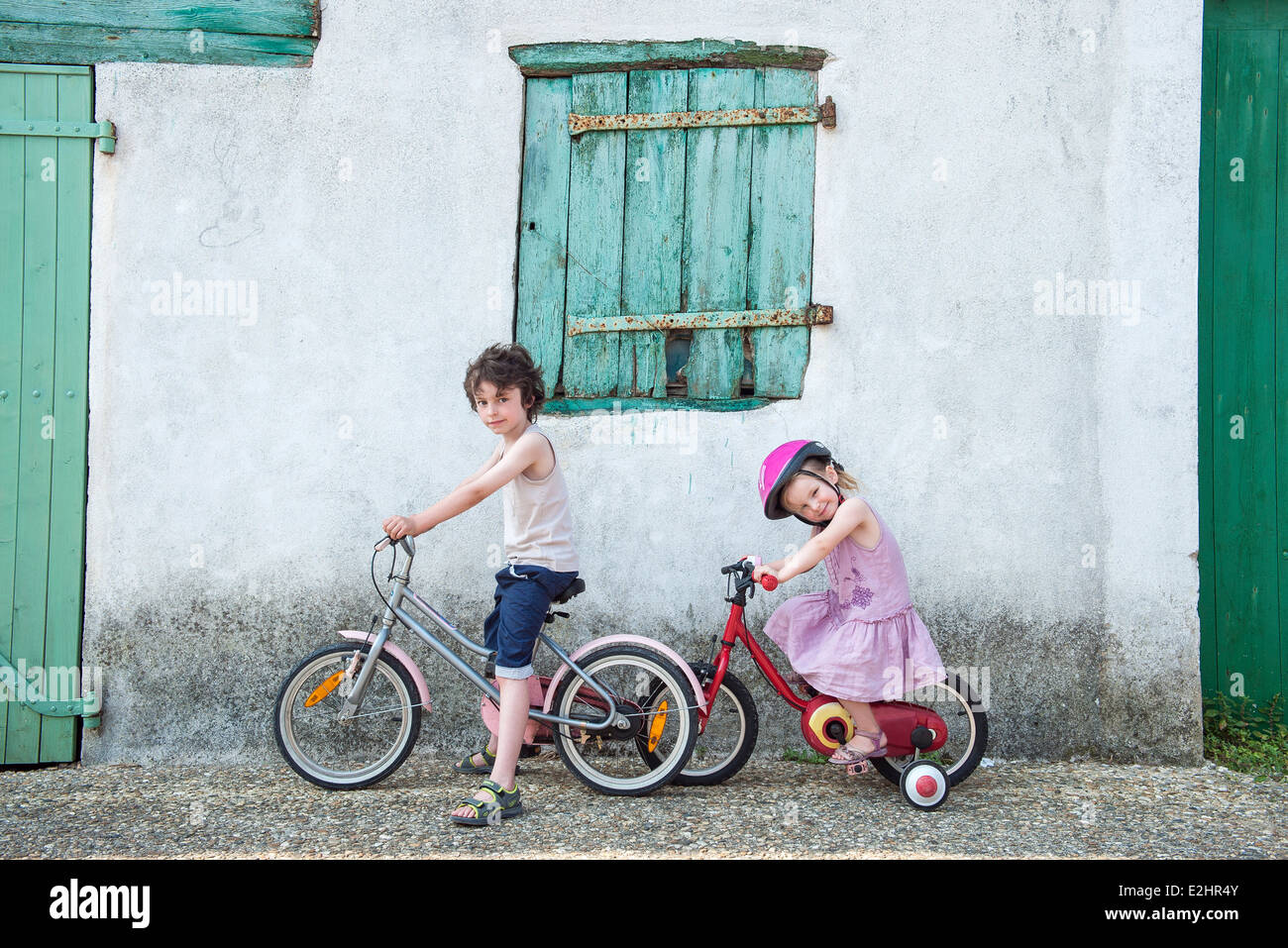 Young brother and sister riding bicycles together Stock Photo - Alamy