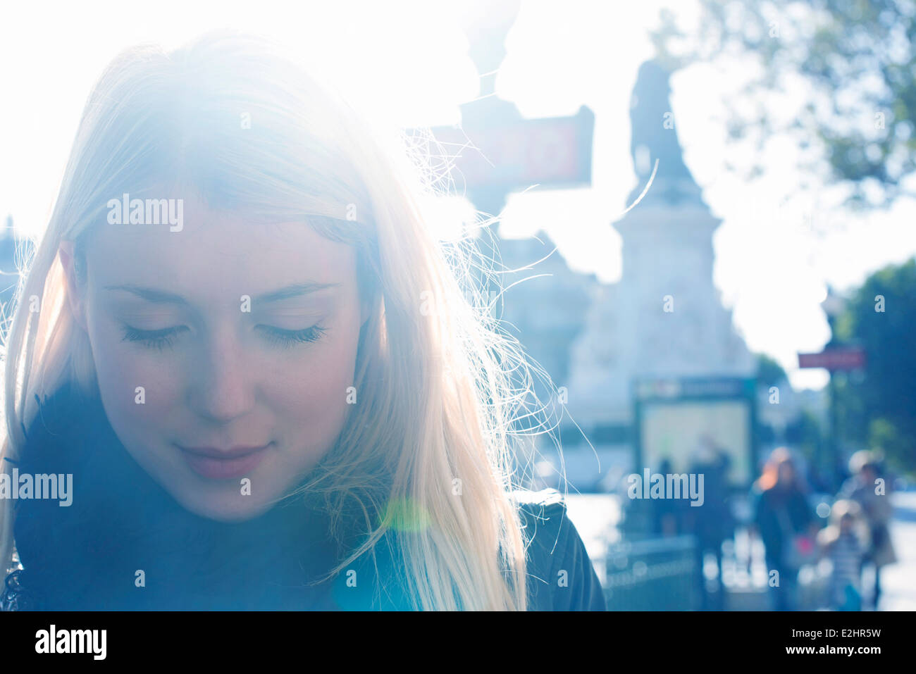 Young woman looking down dreamily outdoors Stock Photo - Alamy
