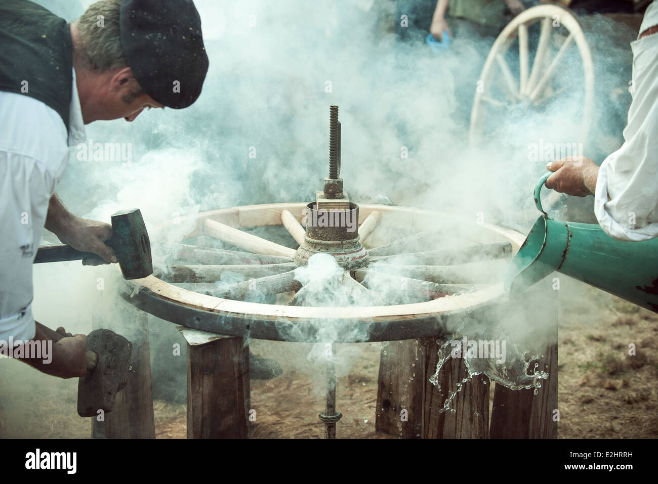 Craftsmen repairing horse-drawn wagon wheel Stock Photo - Alamy