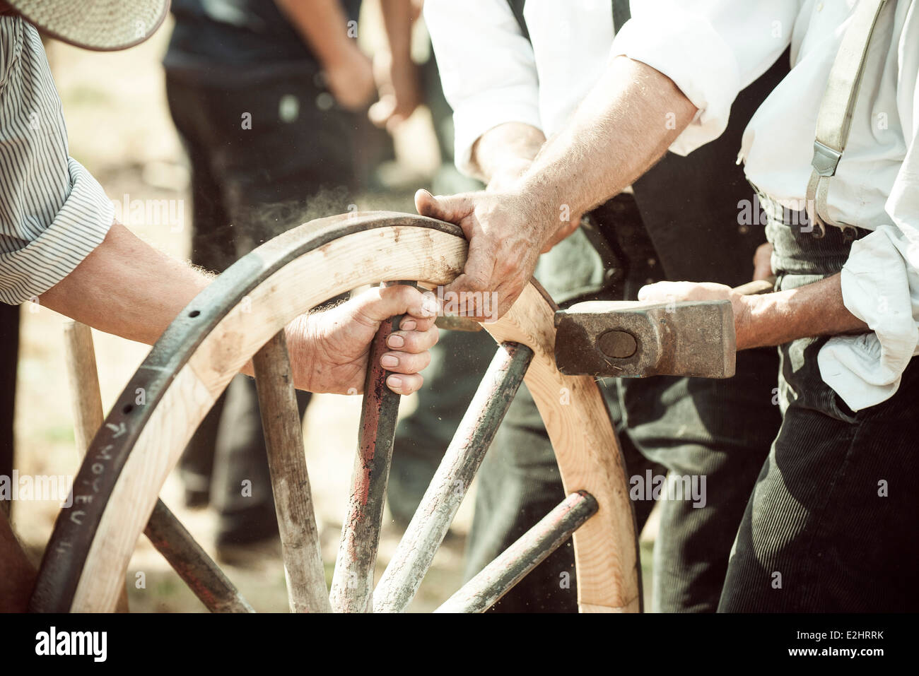 Craftsmen repairing horse-drawn wagon wheel Stock Photo - Alamy