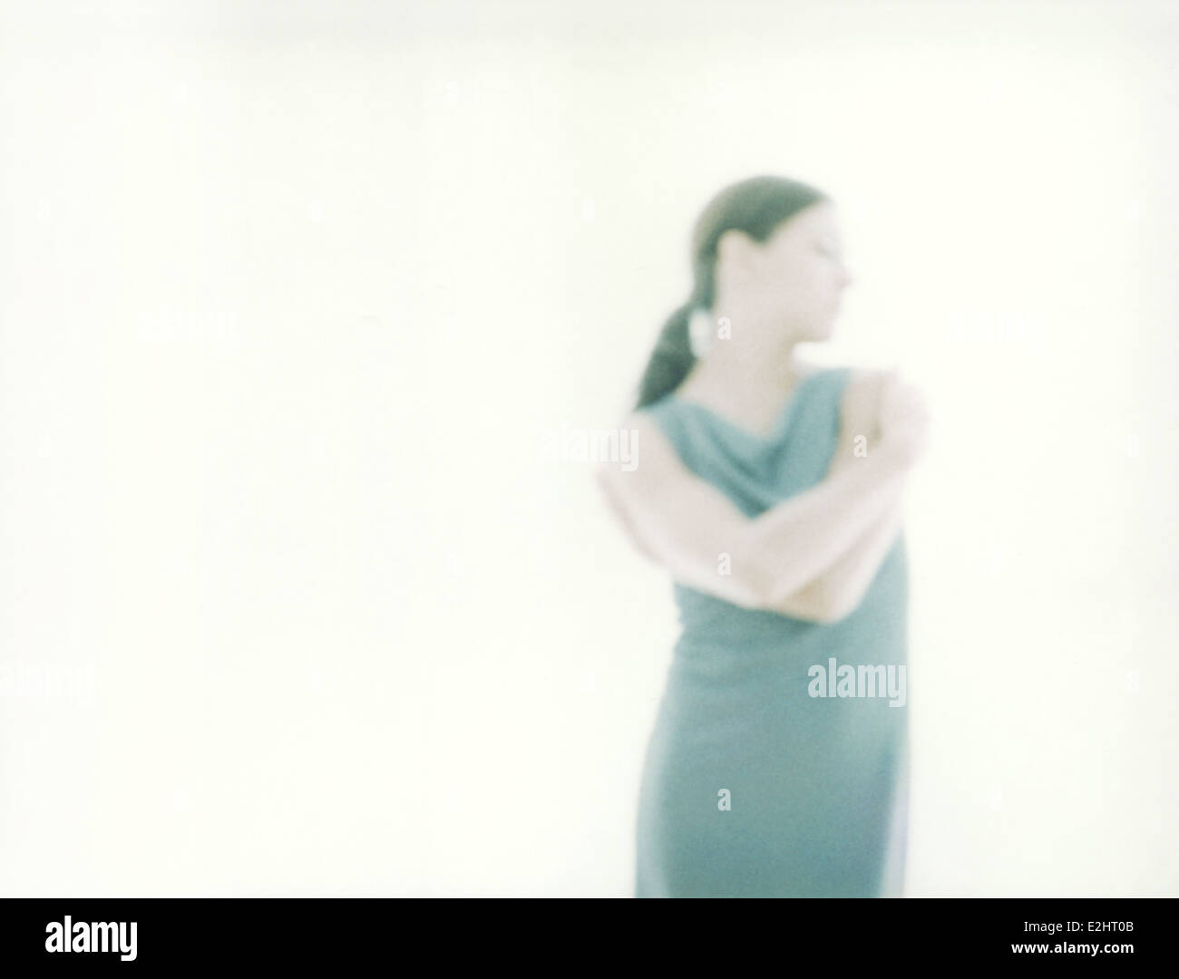 Woman standing with arms across chest, defocused and overexposed Stock ...
