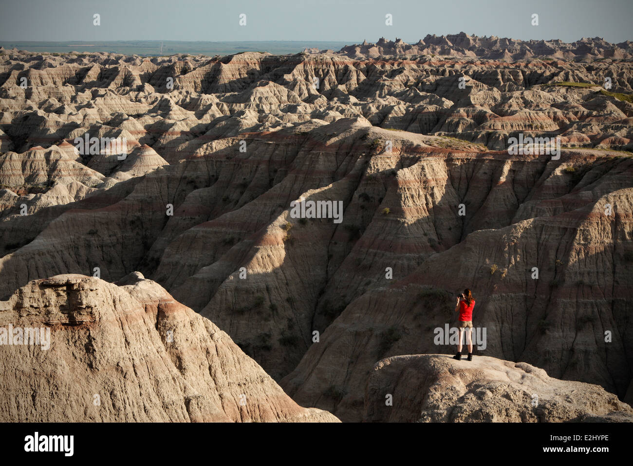 Woman in red shirt taking photograph at Badlands National Park in South ...