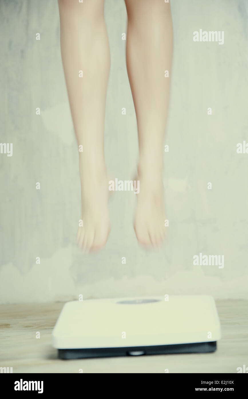 Woman's legs floating above bathroom scale Stock Photo - Alamy