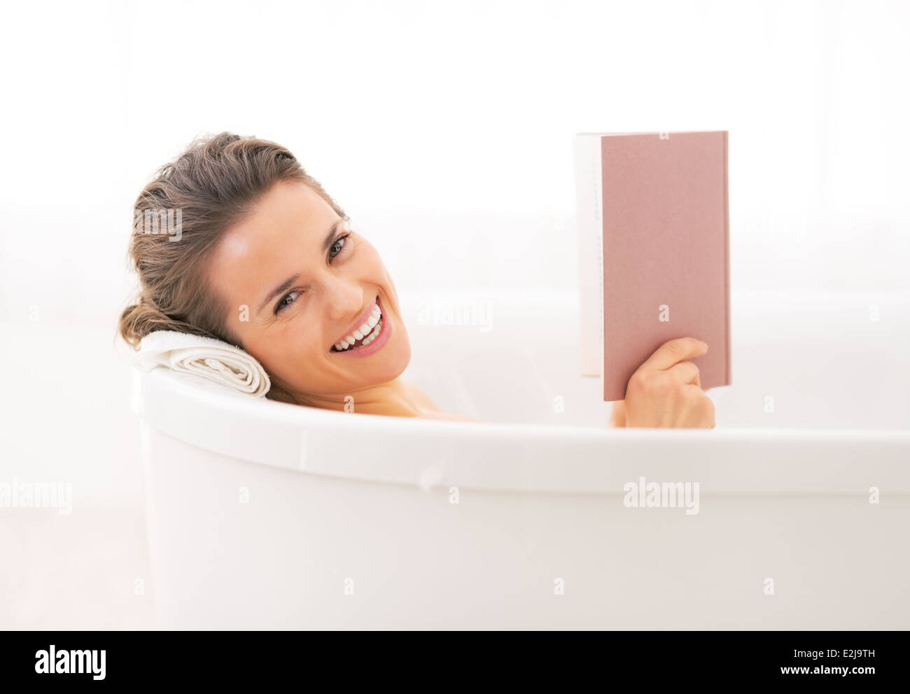 Happy young woman reading book in bathtub Stock Photo - Alamy
