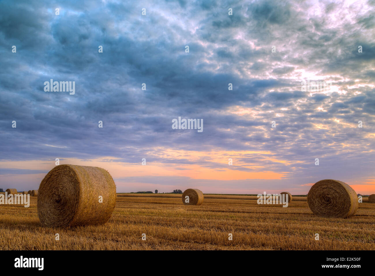 Sunset over farm field with hay bales Stock Photo - Alamy