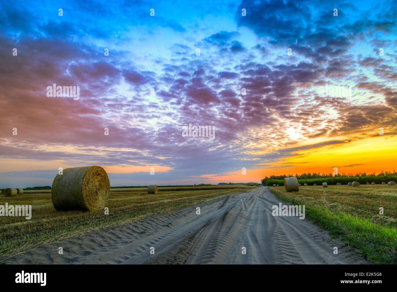 Sunset over rural road and farm field with hay bales-This photo make ...