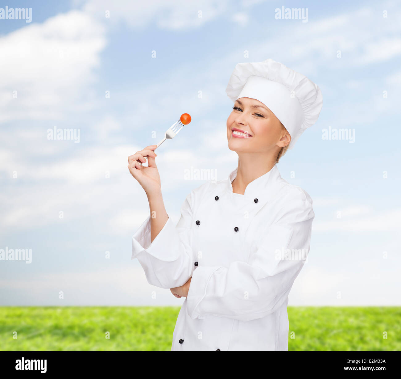 smiling female chef with fork and tomato Stock Photo - Alamy