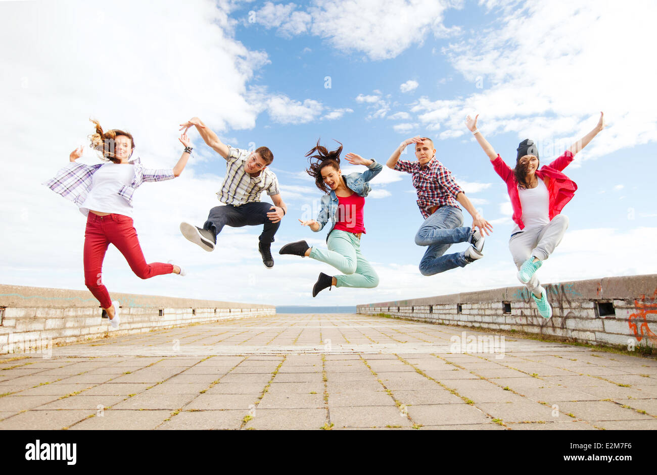group of teenagers jumping Stock Photo - Alamy