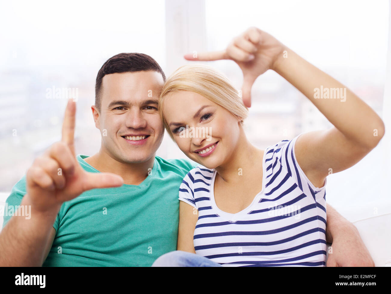 smiling happy couple making frame gesture at home Stock Photo - Alamy