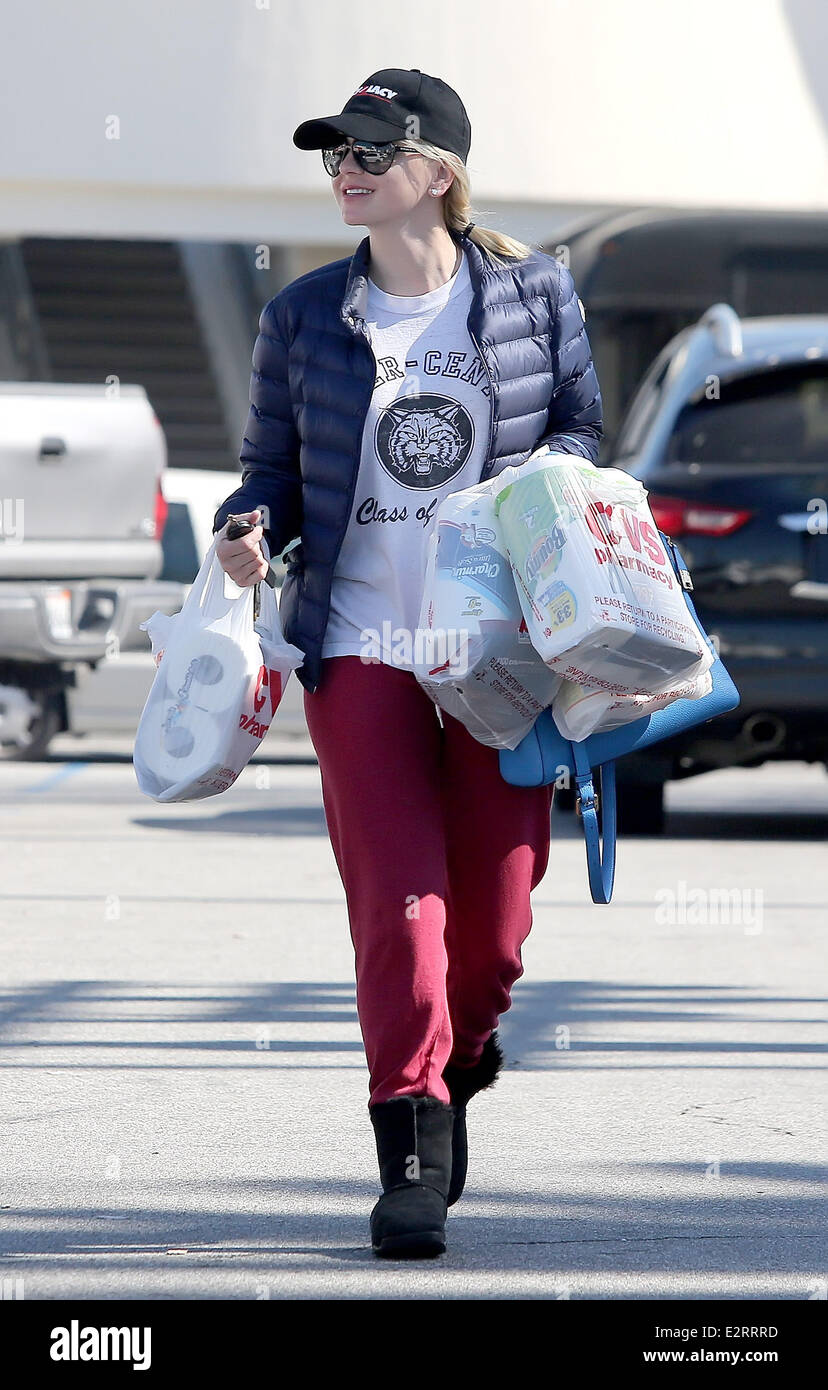 Anna Faris, wearing sweatpants, has her hands full with shopping bags ...