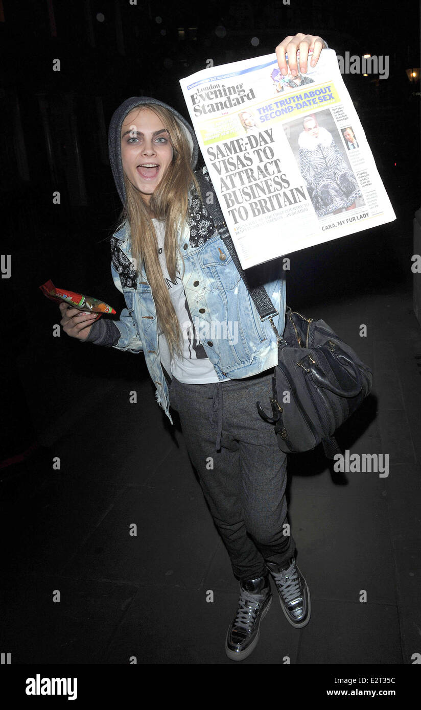 A delighted Cara Delevingne holds up a copy of the London Evening ...