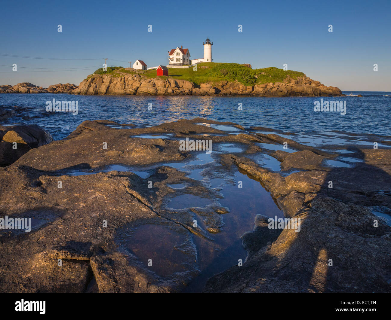 The Nubble lighthouse at sunset as seen from shore in York, Maine, USA ...