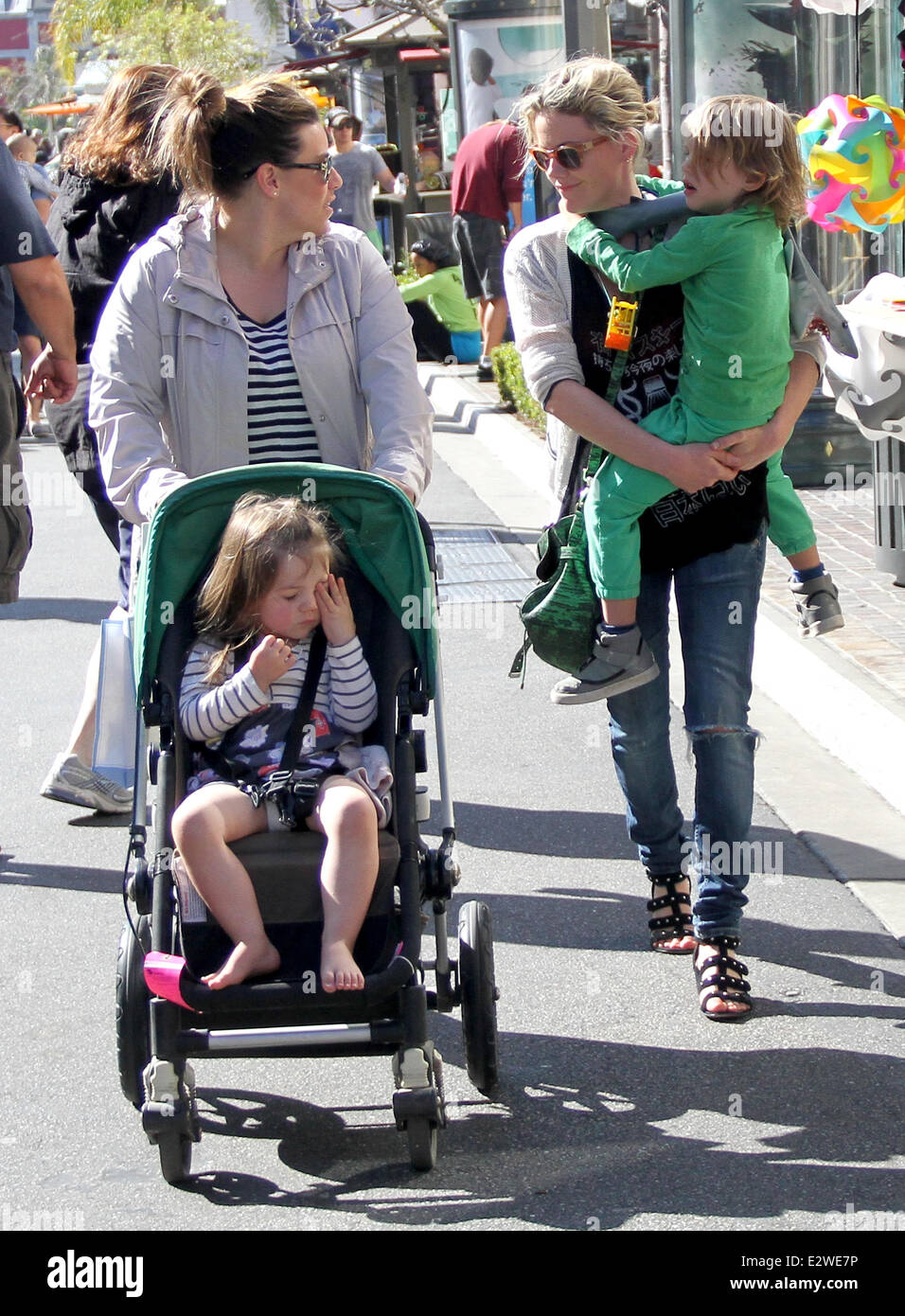 Canadian actress Kathleen Robertson (R) carries her son as she talks ...