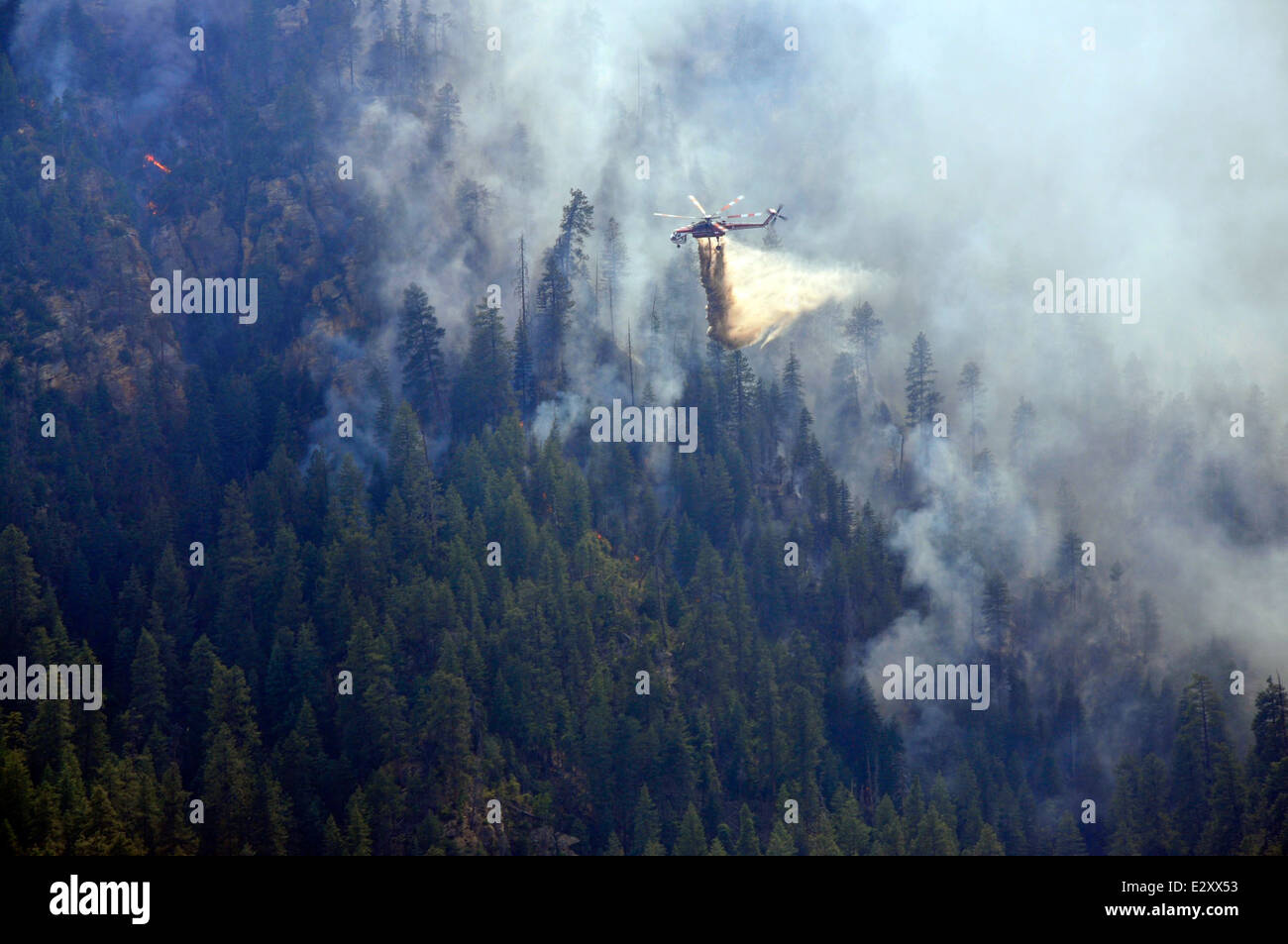 A helicopter drops water over the Slide Fire in Oak Creek Canyon ...