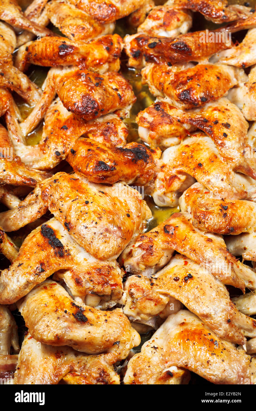 lot of fried spicy chicken wings on hot tray Stock Photo - Alamy