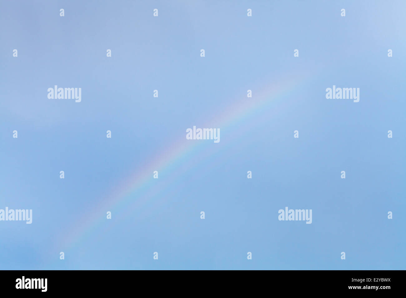 Rainbow in blue sky with white clouds hi-res stock photography and ...