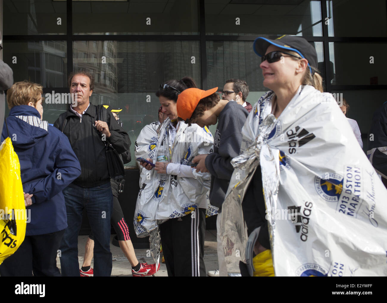 Runners wait news and loved ones after an explosion during the Boston ...