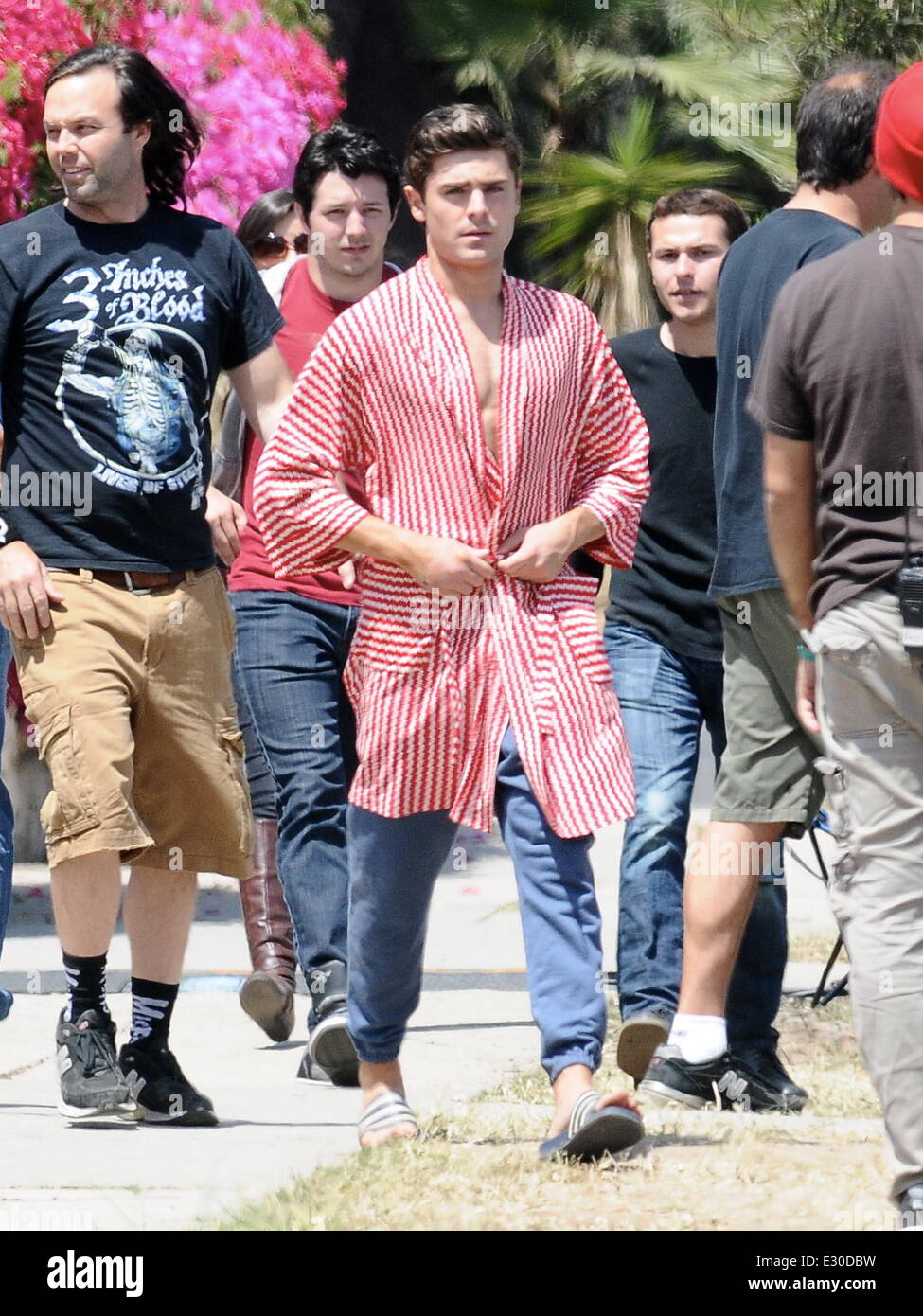 Zac Efron wears a red and white striped robe exposing part of his chest ...
