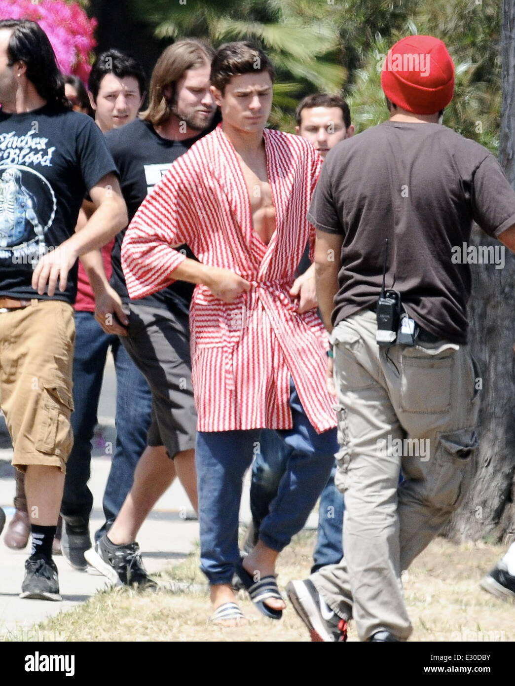Zac Efron wears a red and white striped robe exposing part of his chest ...