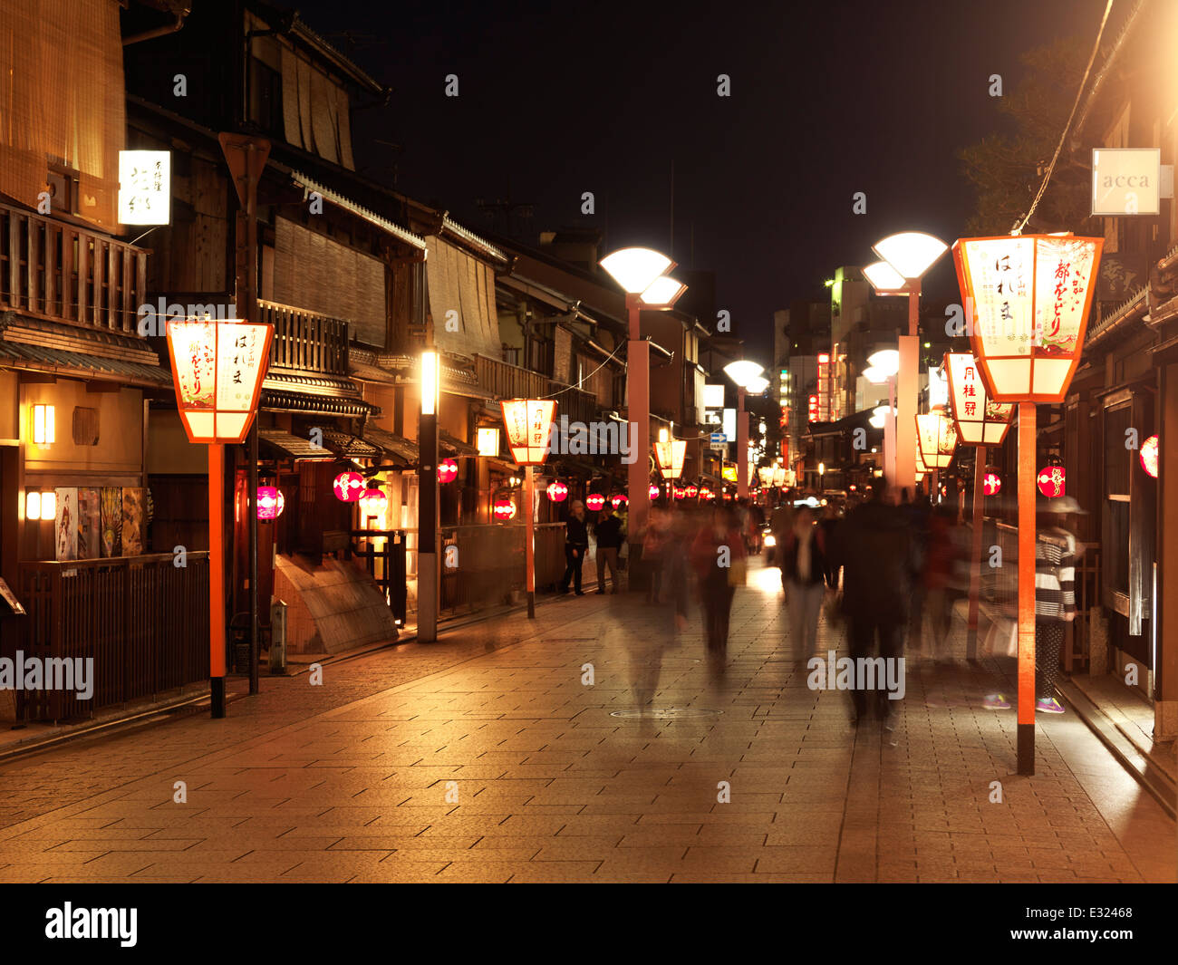People walking on brightly lit Hanami-koji dori street at nighttime ...