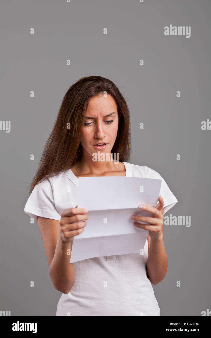 brunette young woman realizes that something wrong happened reading a ...