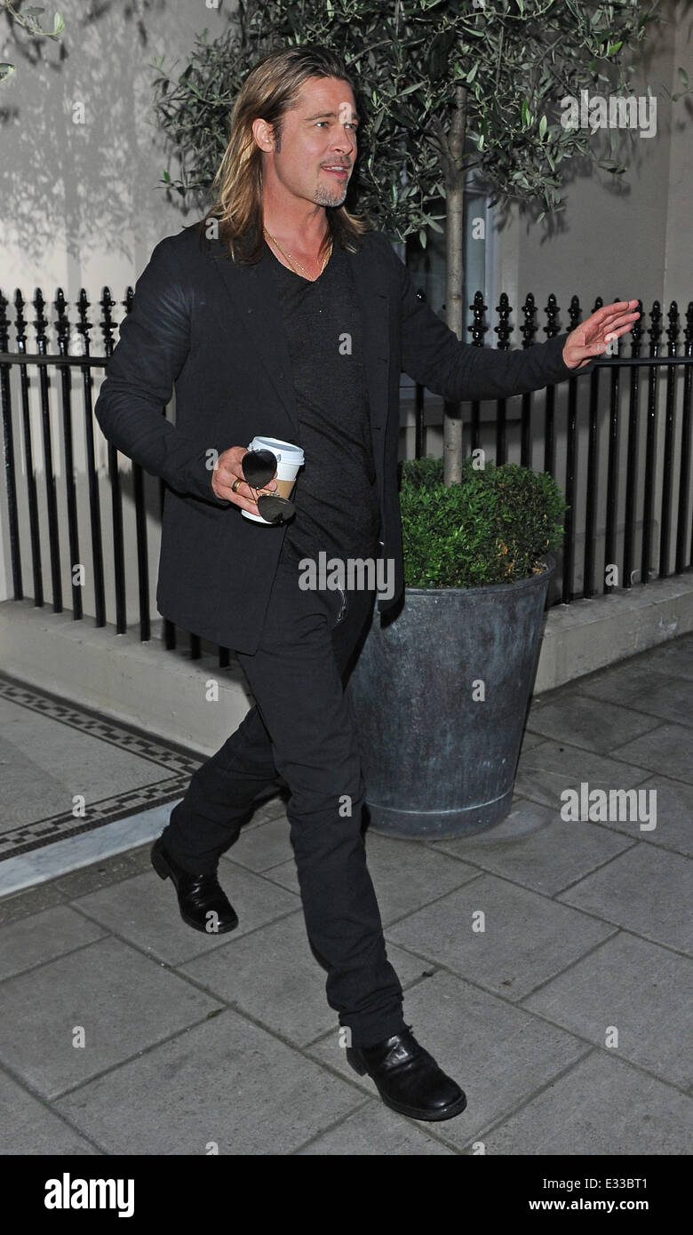 Brad Pitt, holding a cup of coffee, leaves a private residence to go ...